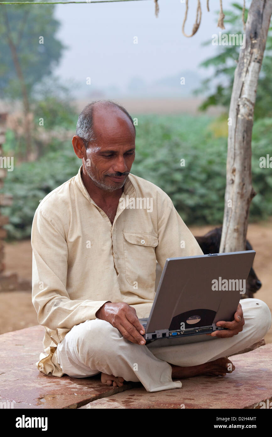 india, Uttar Pradesh, middle-aged man looking at laptop computer in ...