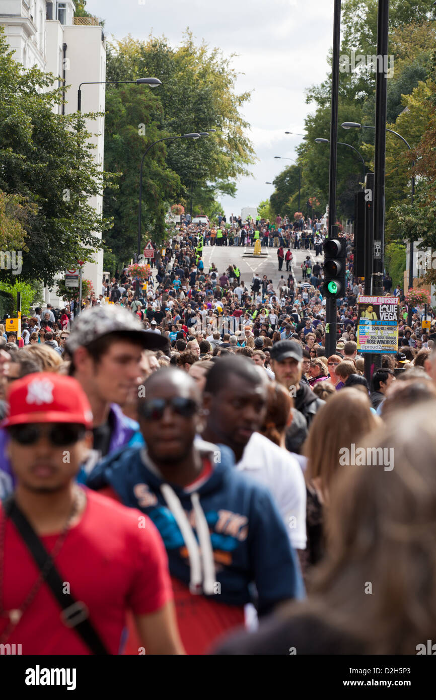 A large crowd of people walk along the parade route at the 2011 Notting ...