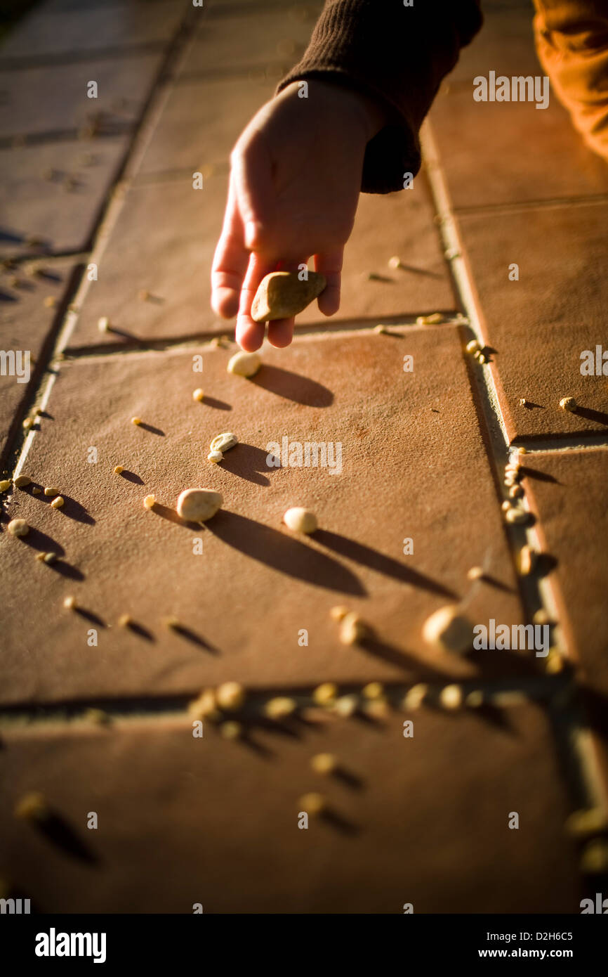 Seville, Spain, a child throwing pebbles on the ground Stock Photo - Alamy