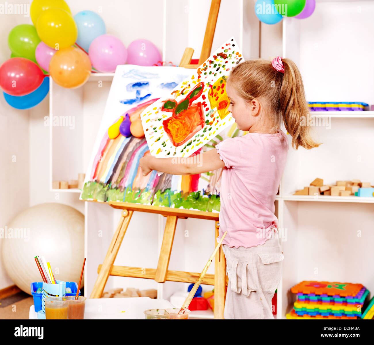 Child painting at easel in school Stock Photo - Alamy