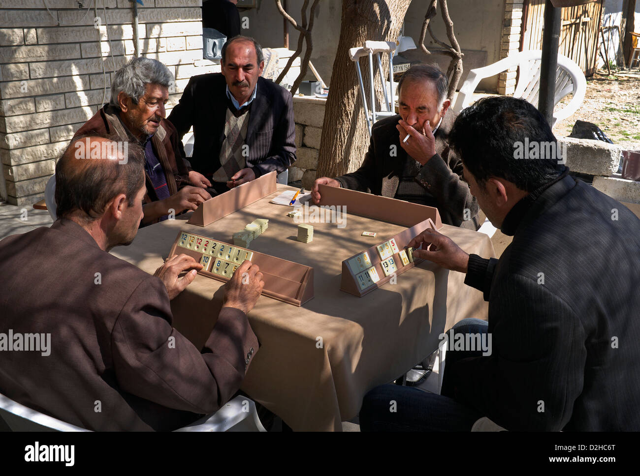 Turkish men playing the tile game of "okay", in a back street cafe ...