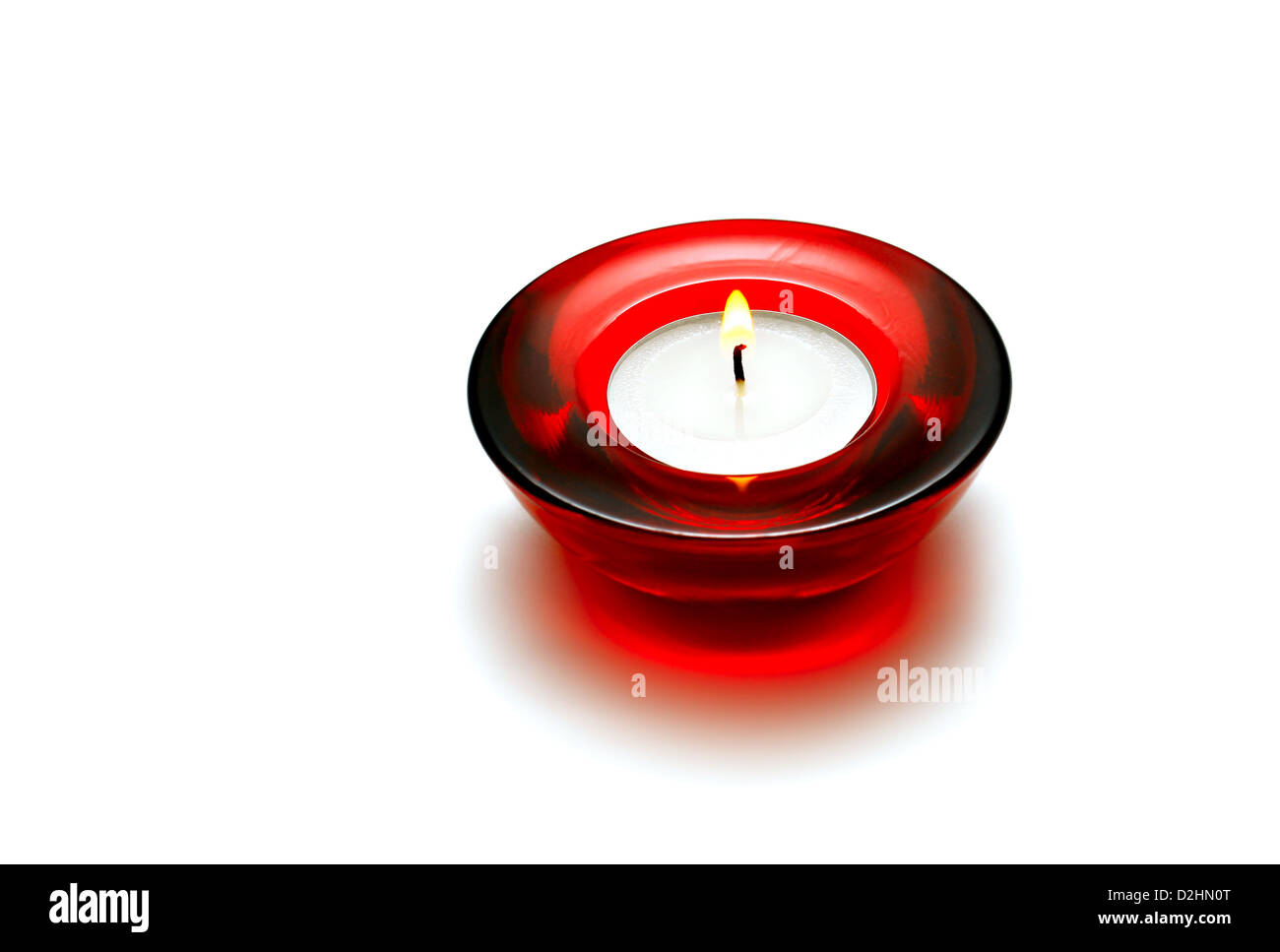 Burning candle in a round red glass candlestick Stock Photo - Alamy