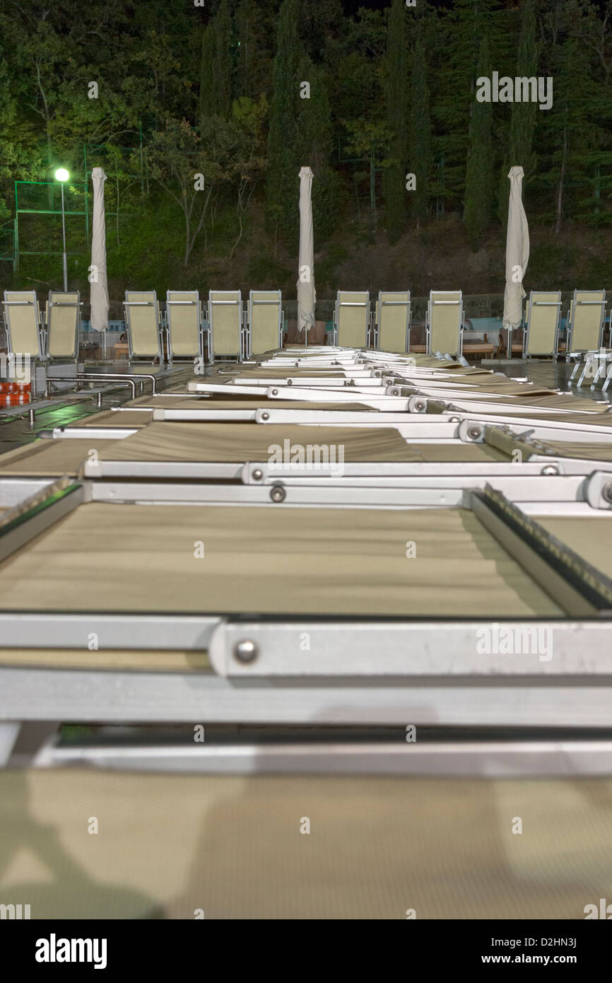 Open air swimming pool with folded deck chairs at night Stock Photo - Alamy