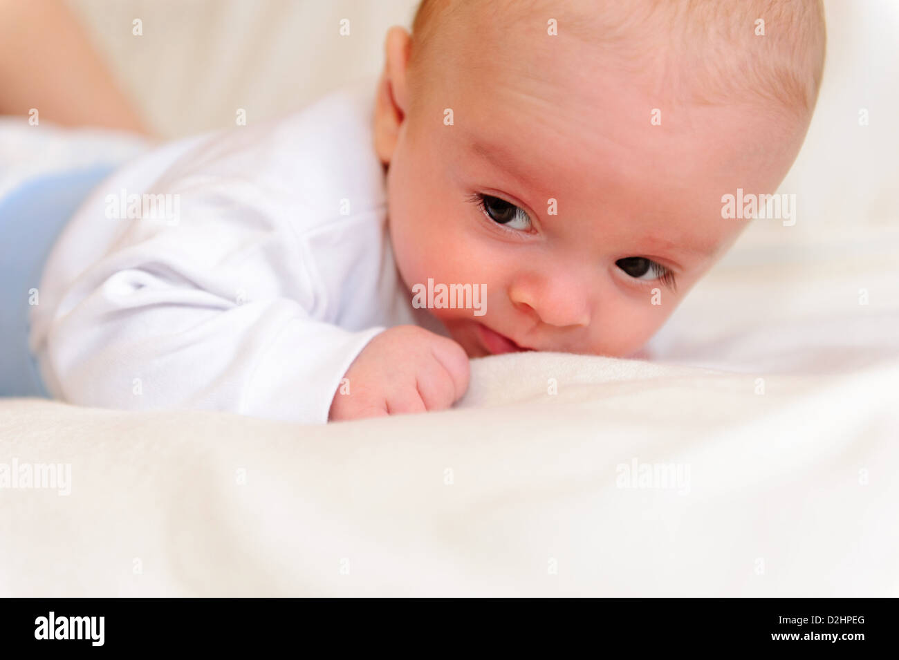 Cute newborn baby lying on stomach in bed Stock Photo - Alamy