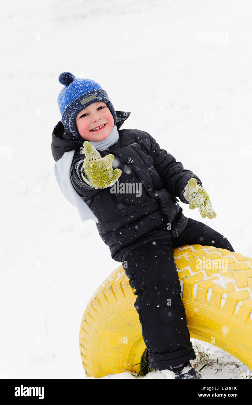 Little boy playing outdoors in snow. Showing thumb up Stock Photo - Alamy