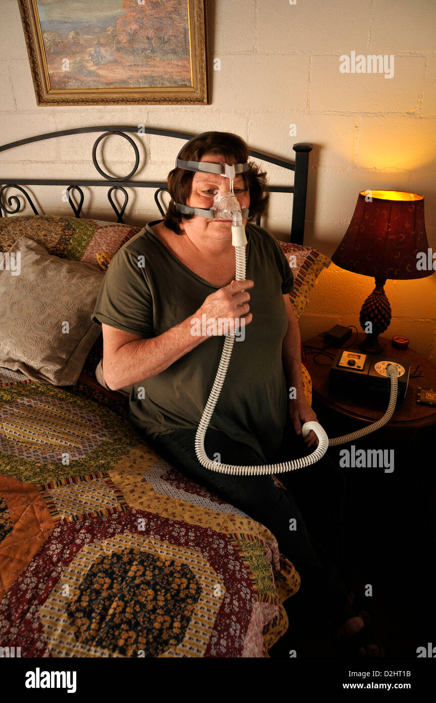 A chronically ill patient applies a bi-pap machine that delivers ...