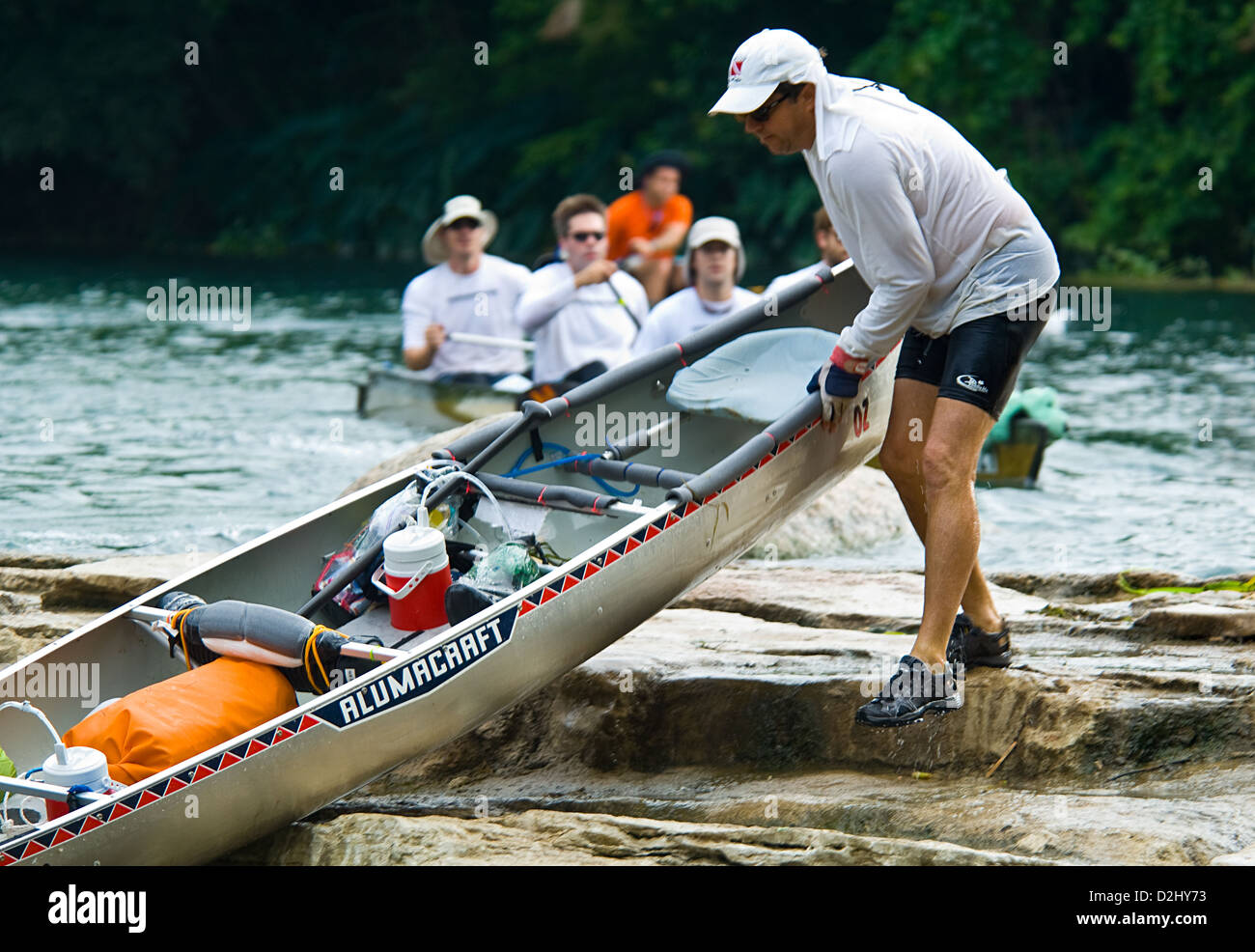 Man portaging his boat over rocks at the Texas Water Safari canoe race ...