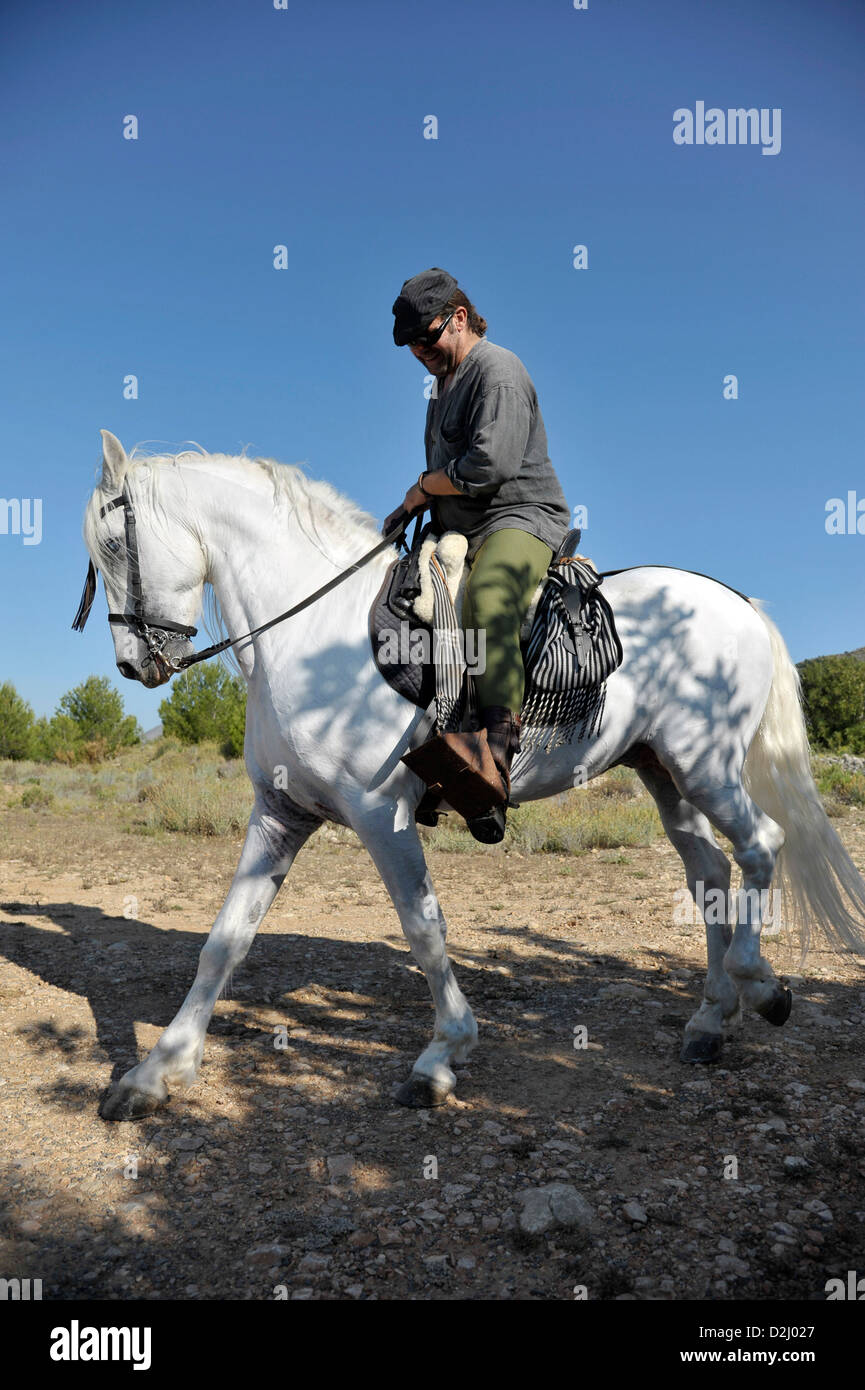 spanish man in his forties and his white Andalusian Gelding outside in ...