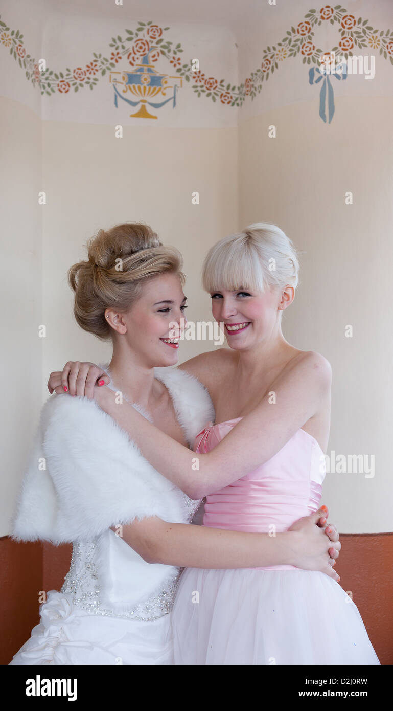 Two attractive young women wearing formal dresses are smiling. Vertical ...