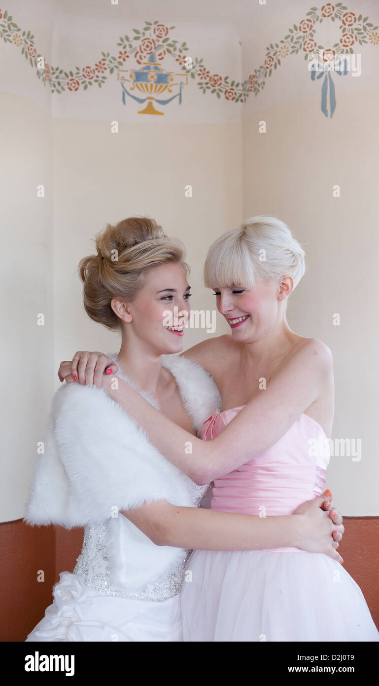 Two attractive young women wearing formal dresses are smiling. Vertical ...