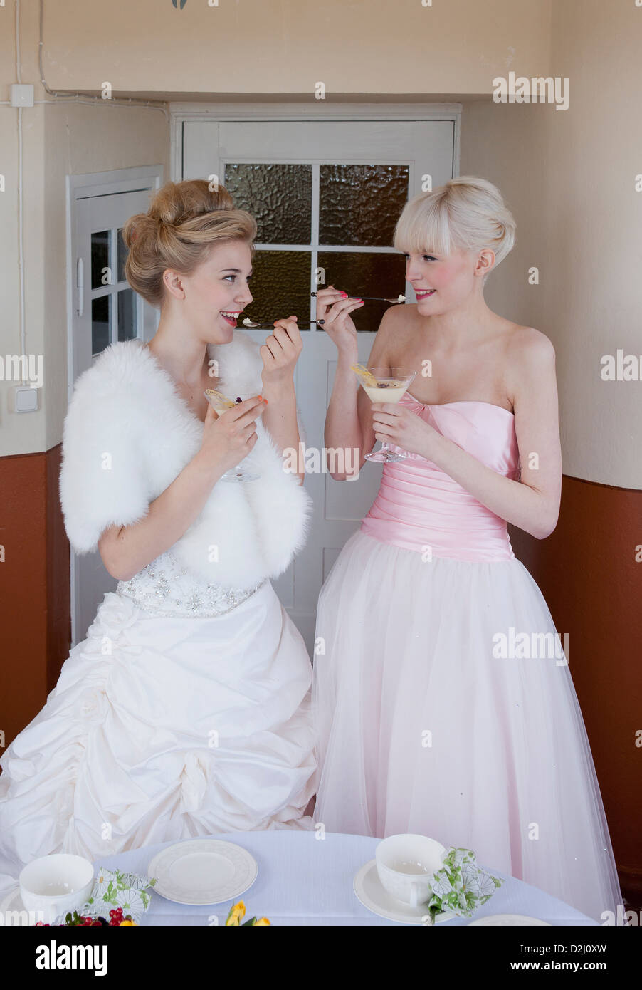 Two attractive young women wearing formal dresses are smiling. Vertical ...