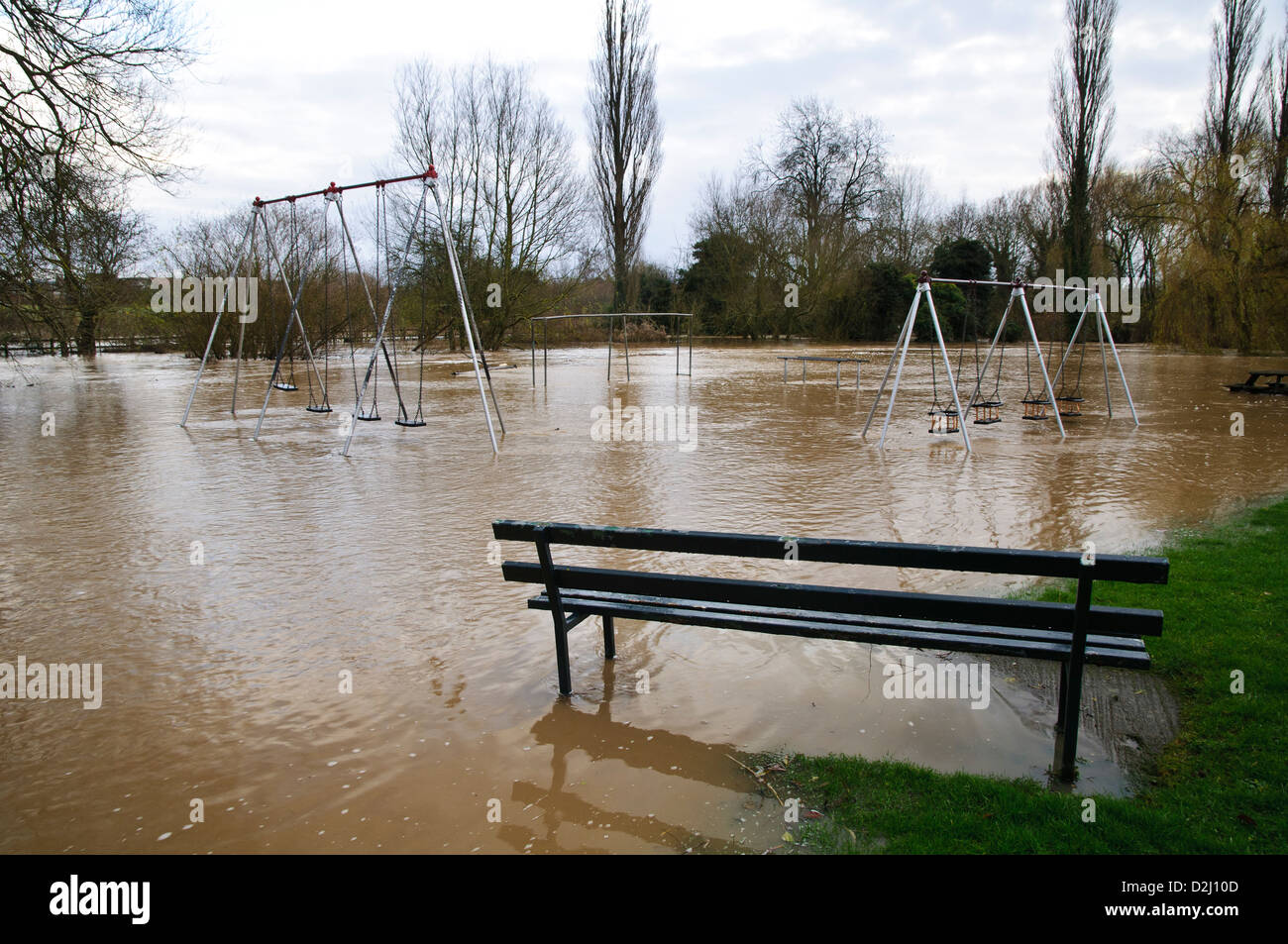 A children's play area with swings and climbing frames inundated by ...