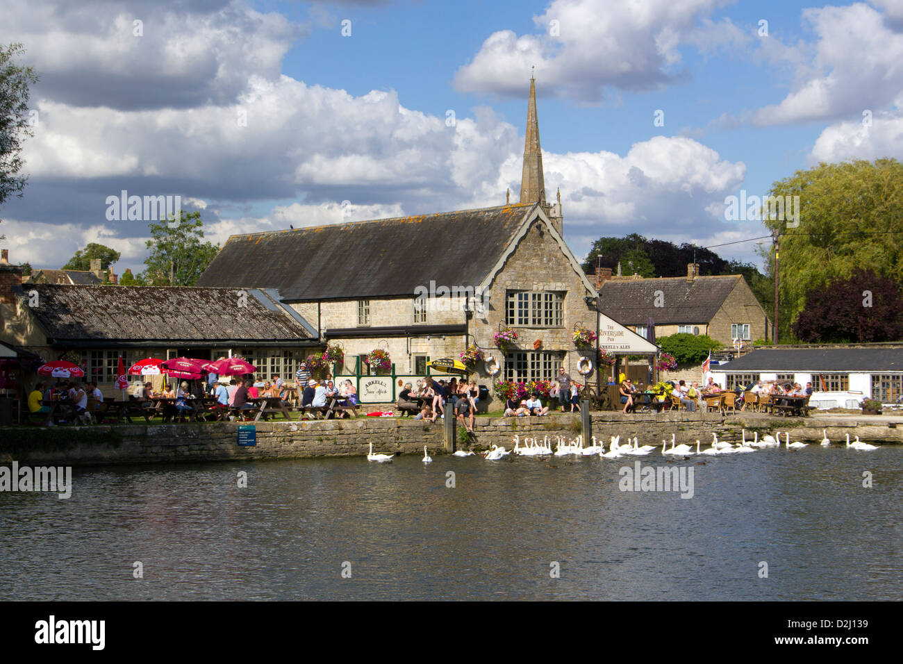 A busy riverside pub garden in summer sunshine on the River Thames in ...