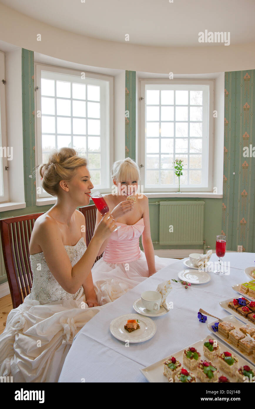 Two attractive young women wearing formal dresses are smiling. Vertical ...