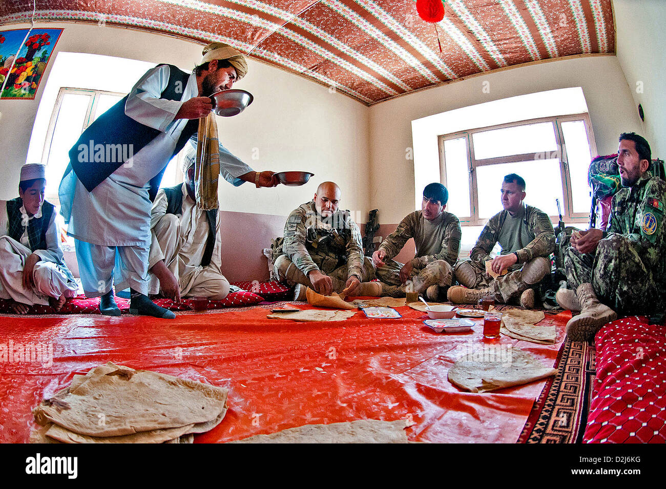 An Afghan villager offers food to US Army soldiers during a meeting ...