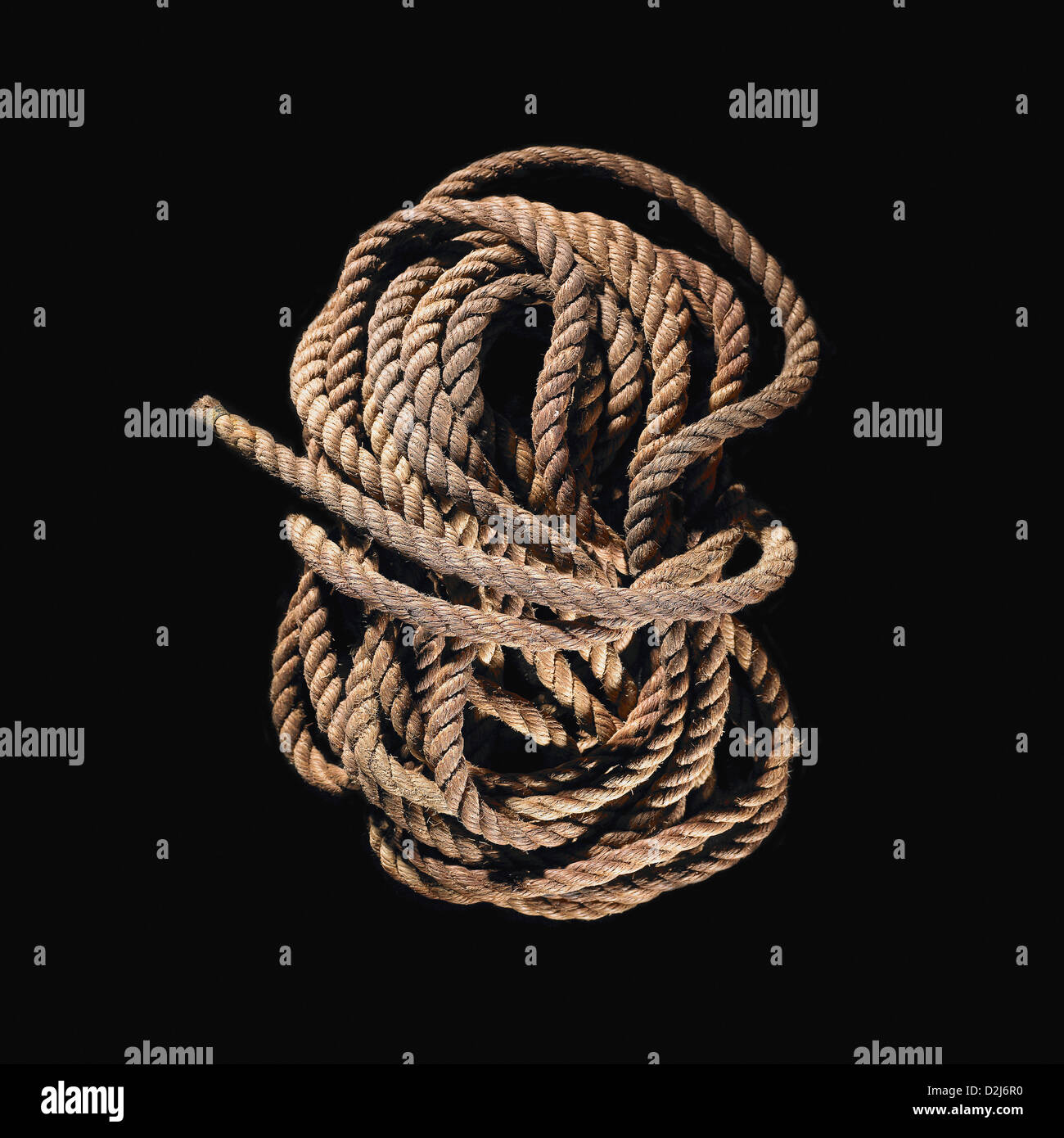 Rope tied up on a black background Stock Photo - Alamy