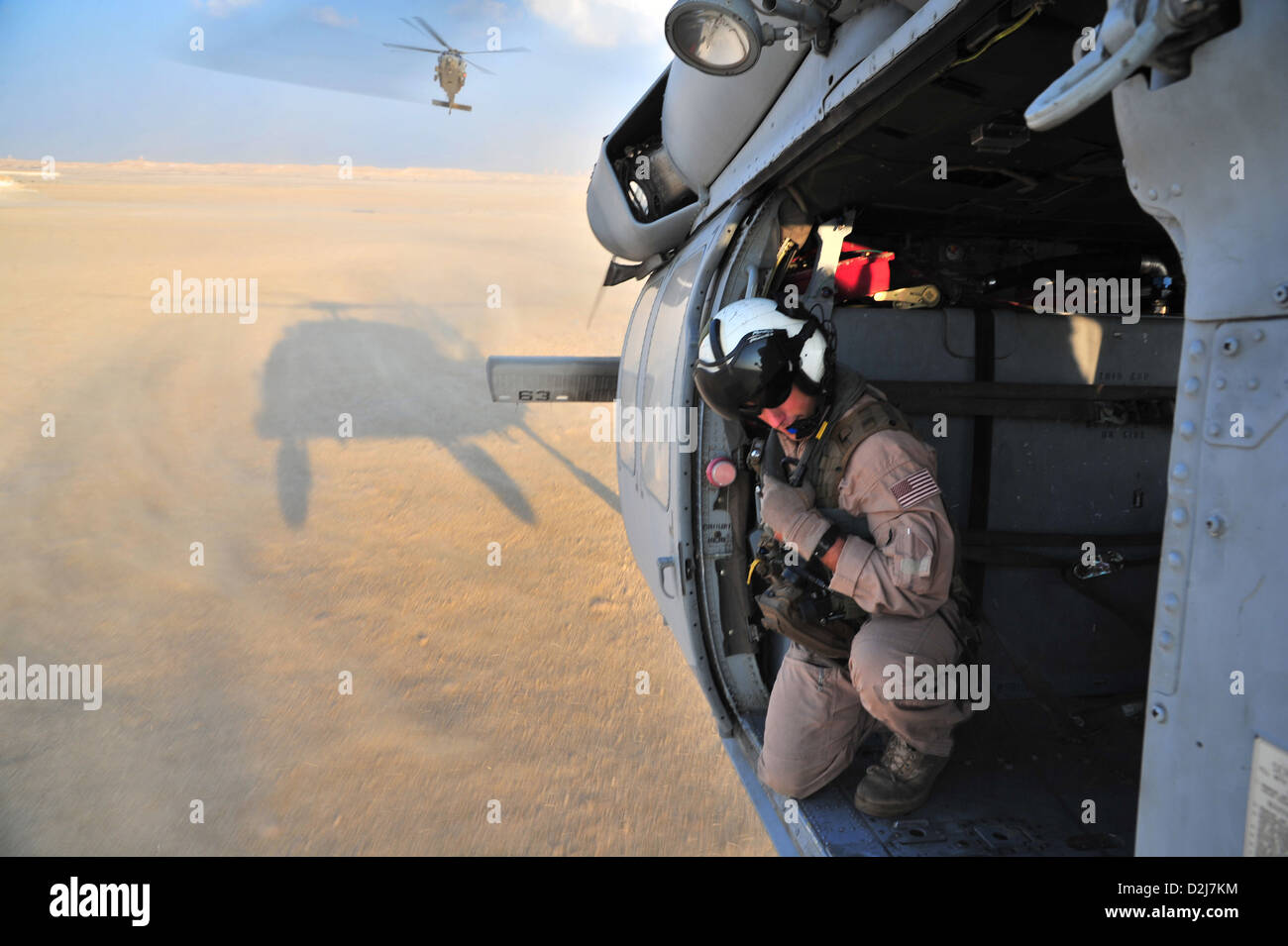 A US Naval Aircrewman scans the landing zone while flying in a MH-60B ...