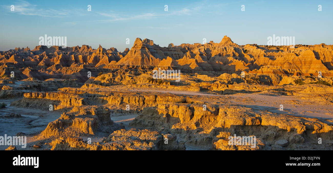 The eroded formations of badlands national park light up at sunrise ...