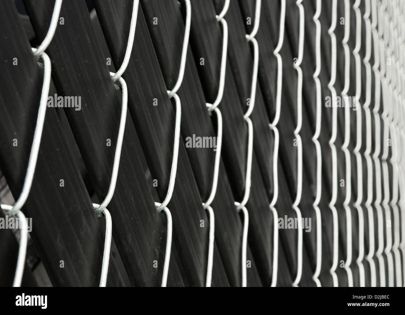 Black plastic strips embedded into cyclone fence taken with extreme ...