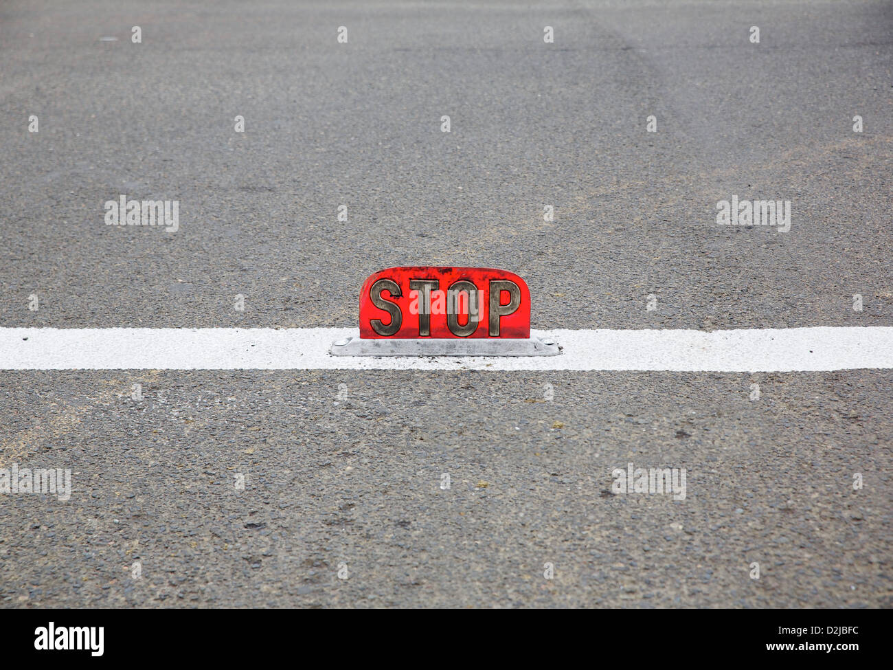 Old style street level stop sign attached to center of the lane on a ...