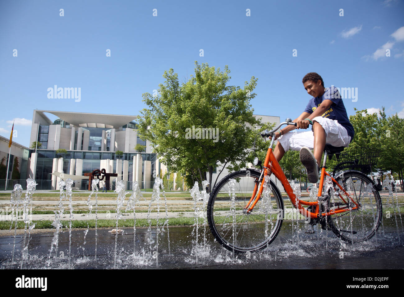 Berlin, Germany, boy rides a bicycle in front of the Chancellery Stock ...