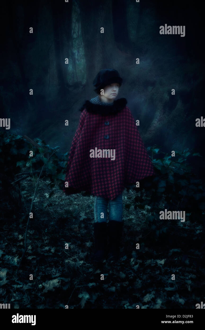 a girl with a red cape in the dark woods Stock Photo - Alamy