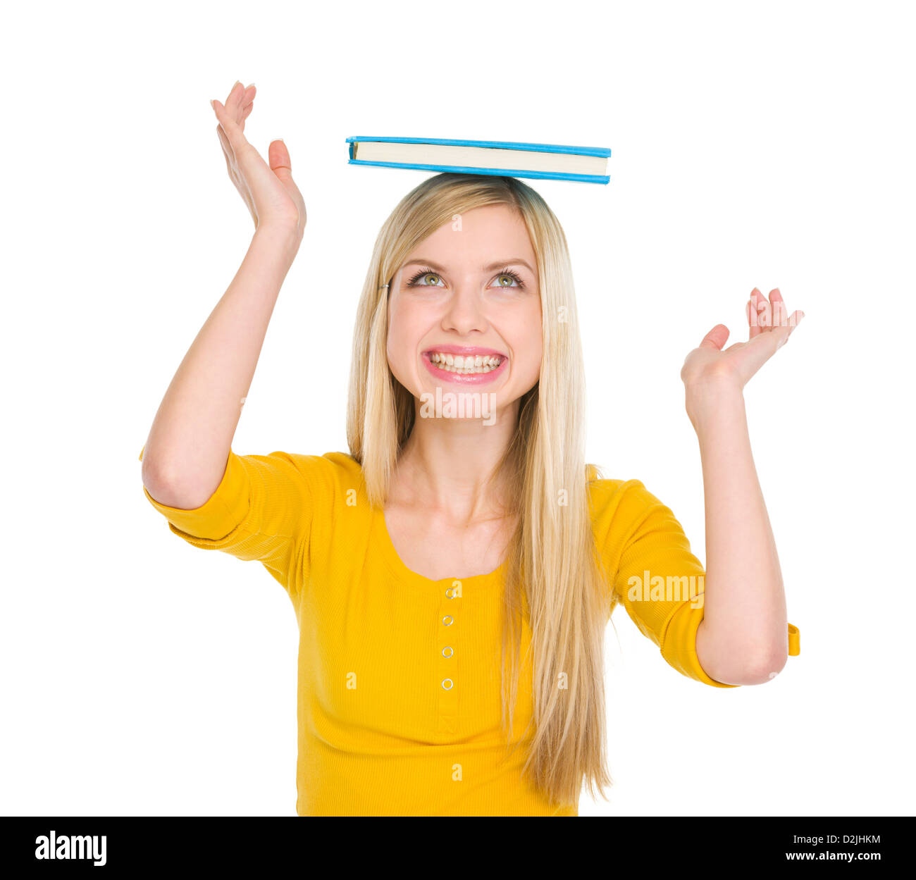 Happy student girl balancing book on head Stock Photo - Alamy