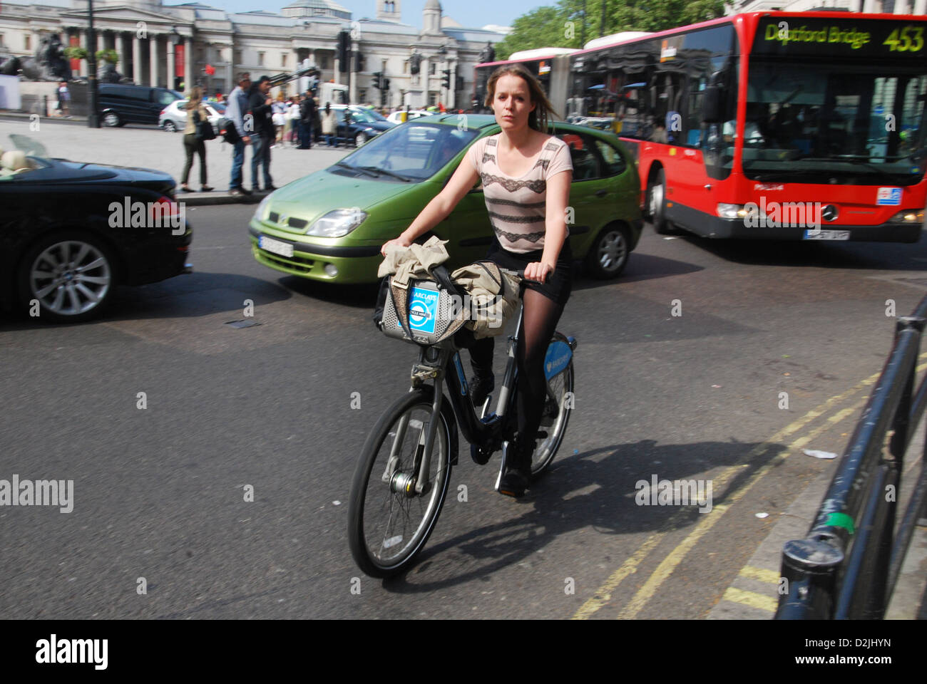 woman cycling among cars, Trafalgar Square London United Kingdom Stock ...
