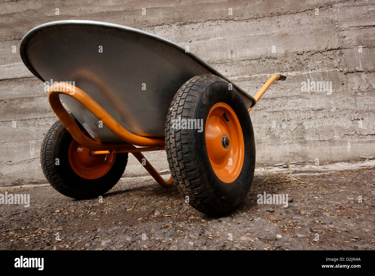 Orange Wheelbarrow on concrete Stock Photo - Alamy