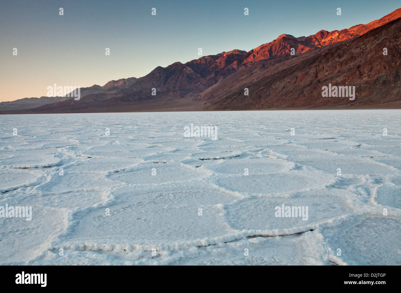 Salt pan polygons below the Black Mountains at Badwater during sunset ...