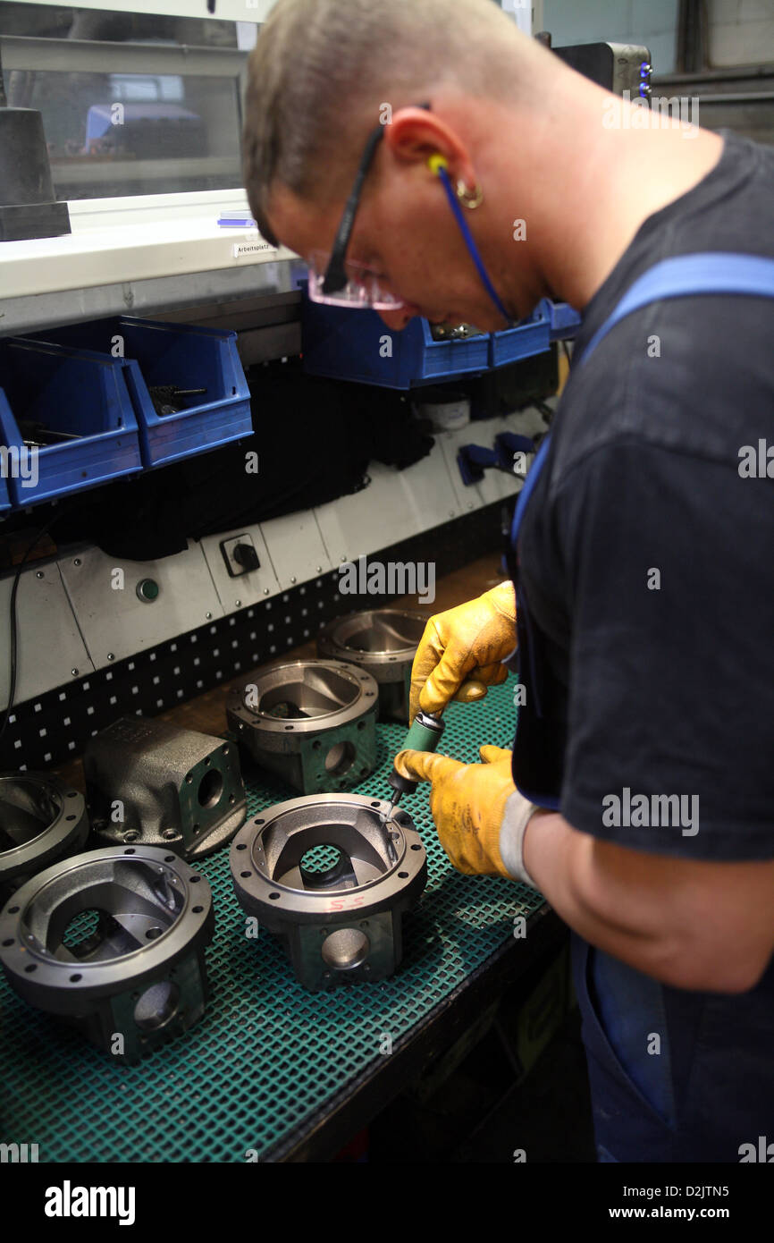 Man removing sharp edges from a hydraulic pump, Berlin, Germany Stock ...