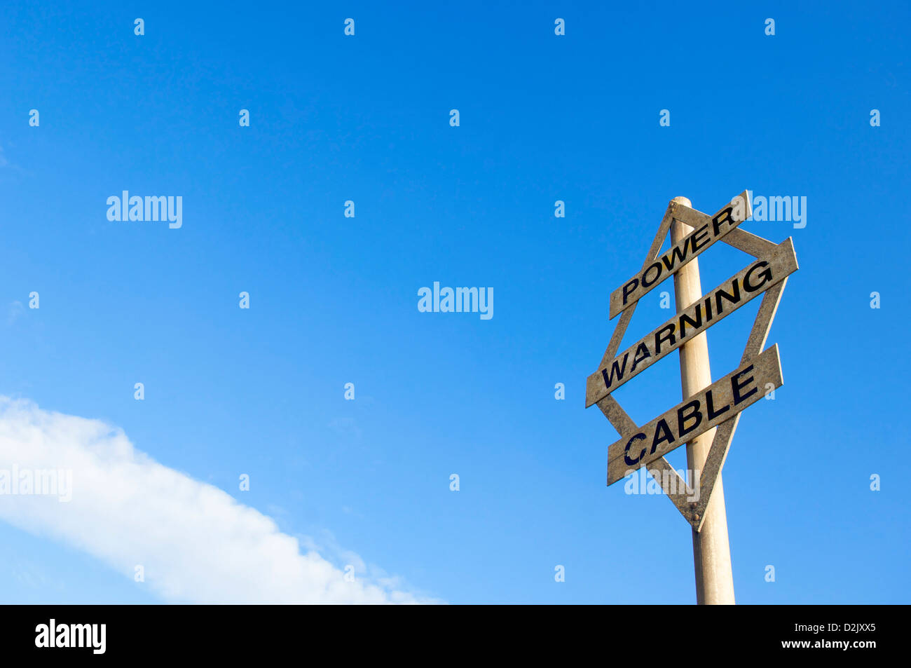 Power cable crossing sign against blue sky Stock Photo - Alamy