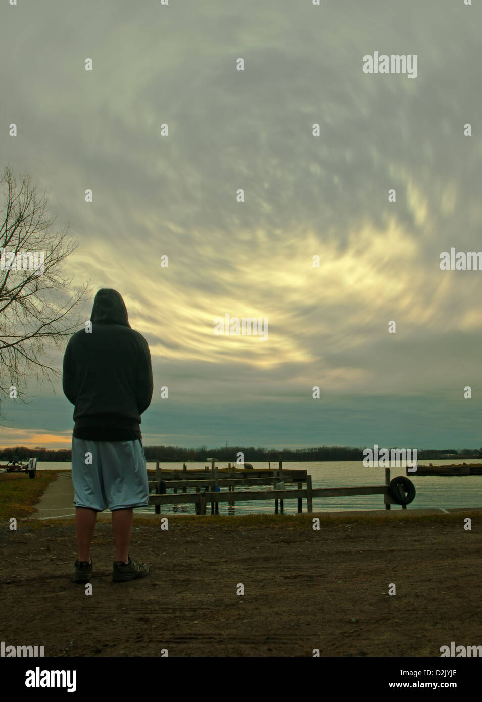 man stands on beach watching a storm beginning Stock Photo - Alamy