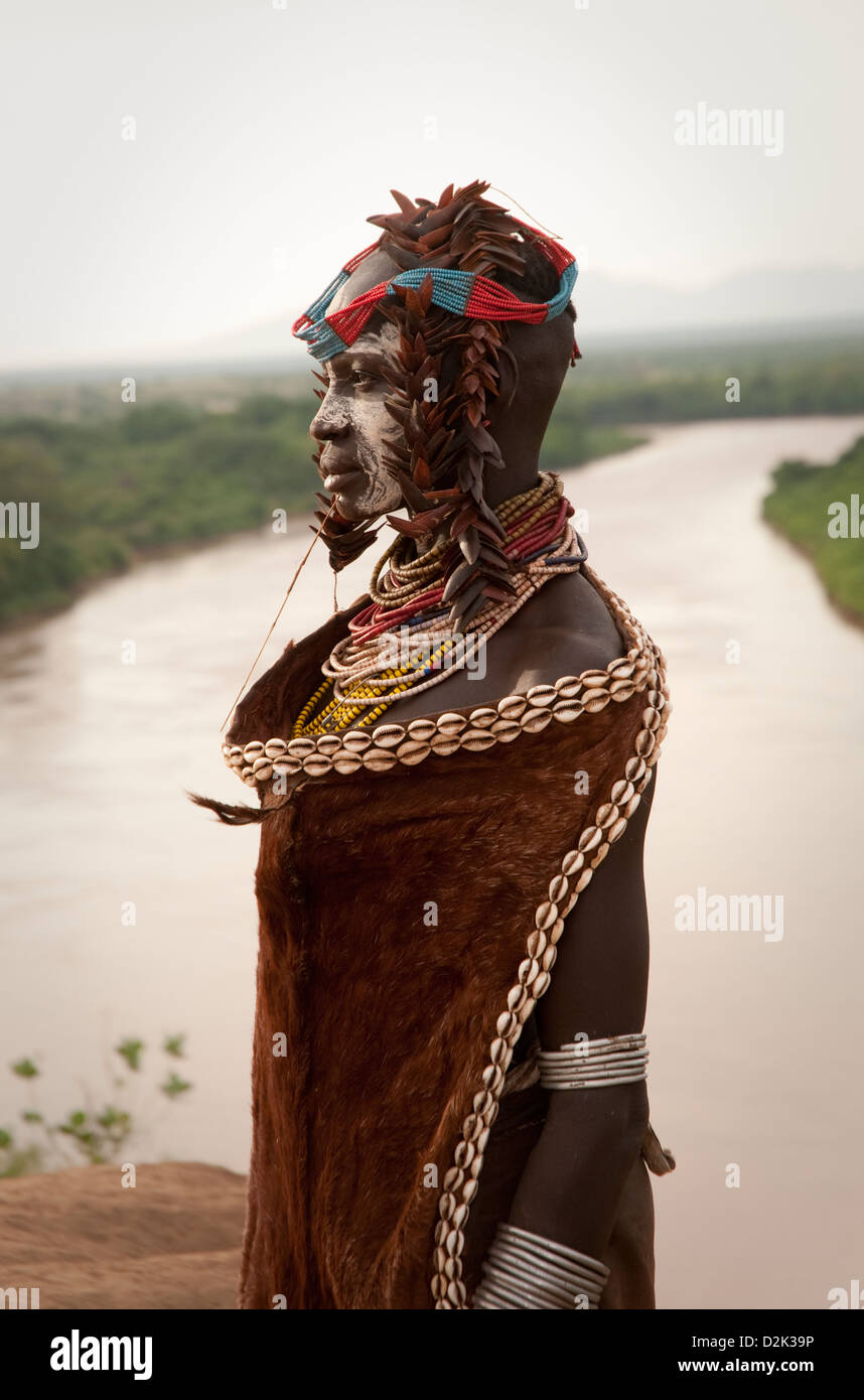 Portrait of decorated Kara woman on bluff with Omo River below-close up ...