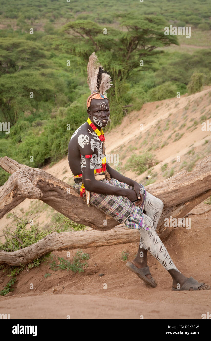 Portrait of decorated Kara man sitting on log Stock Photo - Alamy