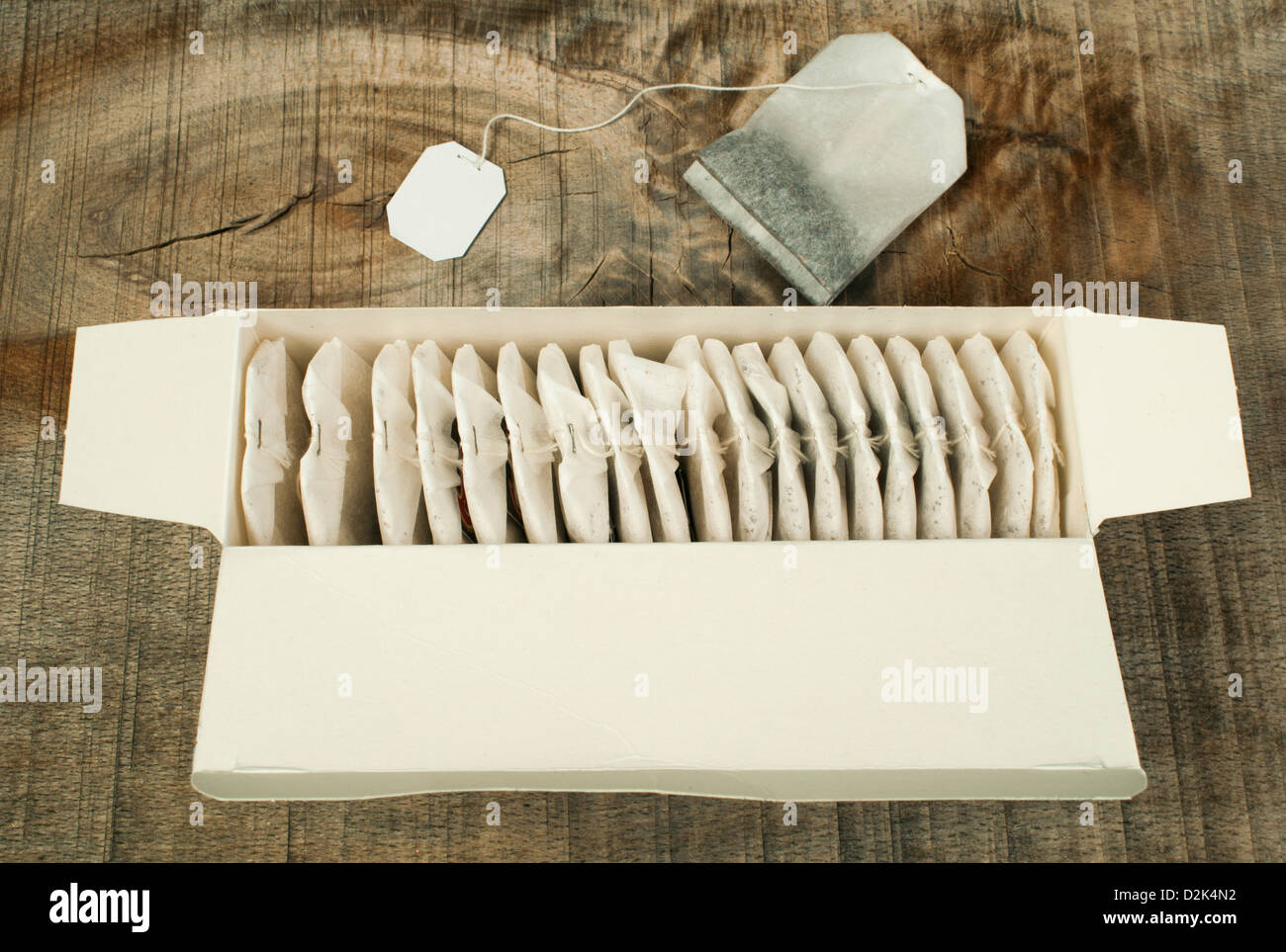 Box with tea bags on wood. Tea bag with label Stock Photo - Alamy