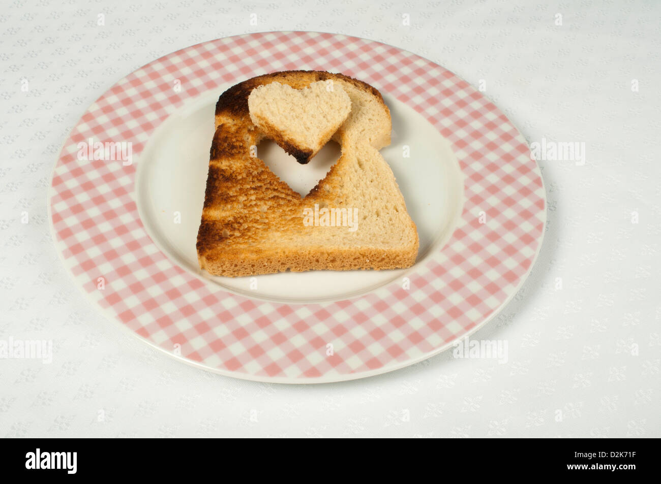 Toast with heart-shaped set in white plate Stock Photo - Alamy
