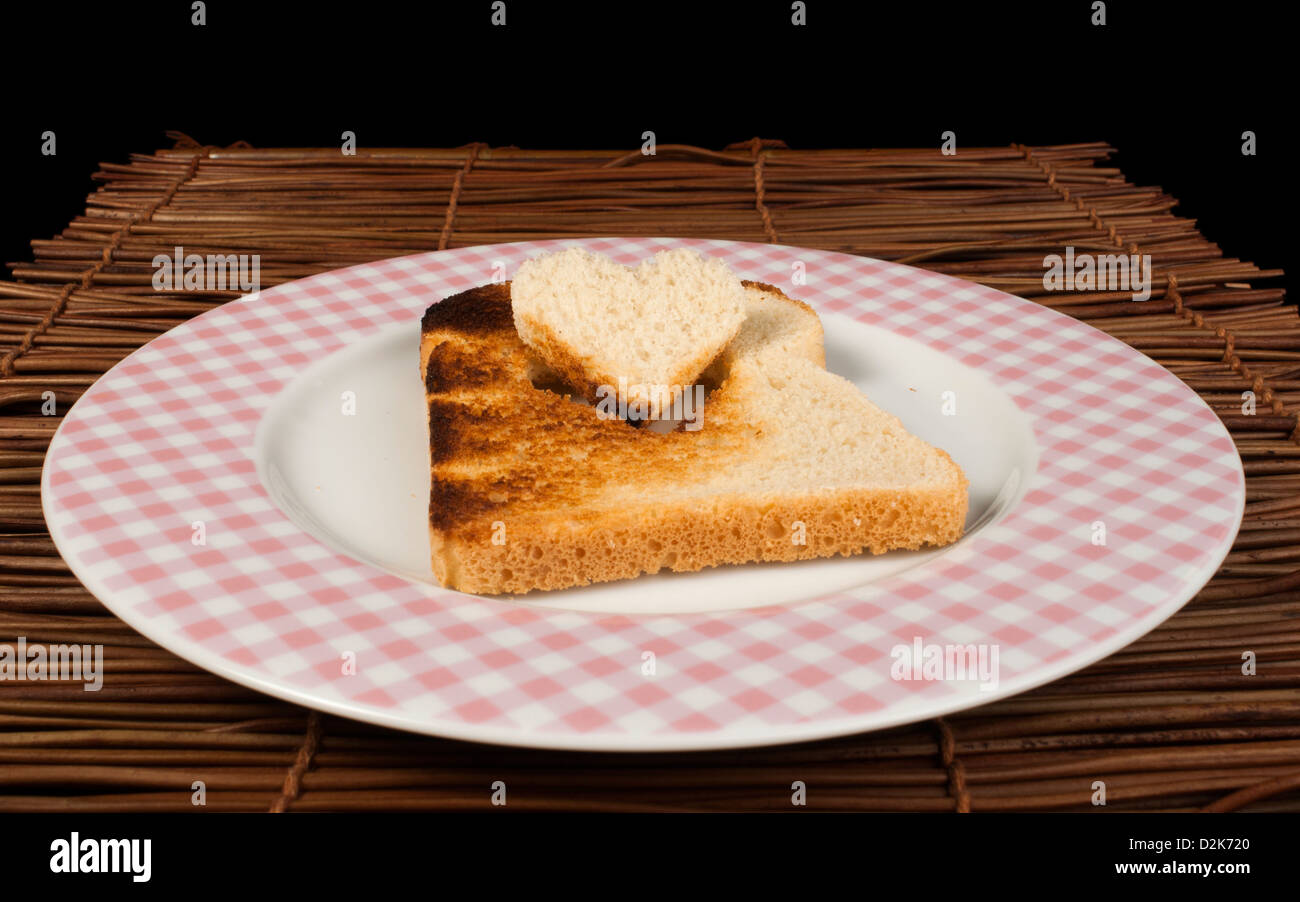 Toast with heart-shaped set in white plate Stock Photo - Alamy