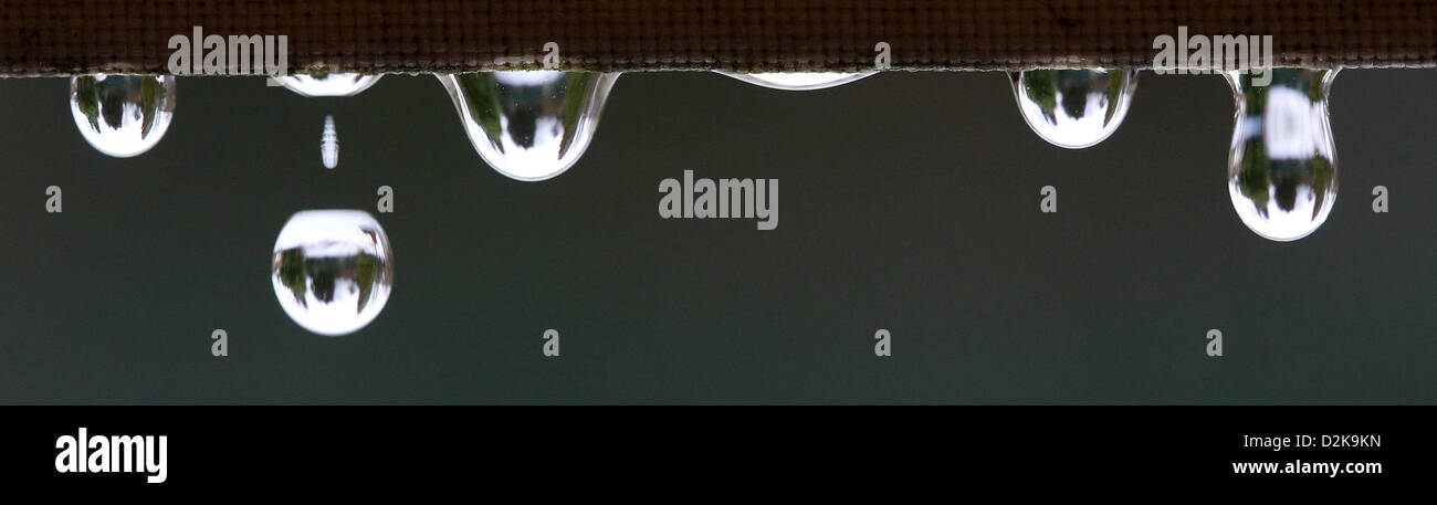Water drops from melting snow fall from a roof in Neukirchen-Vluyn ...