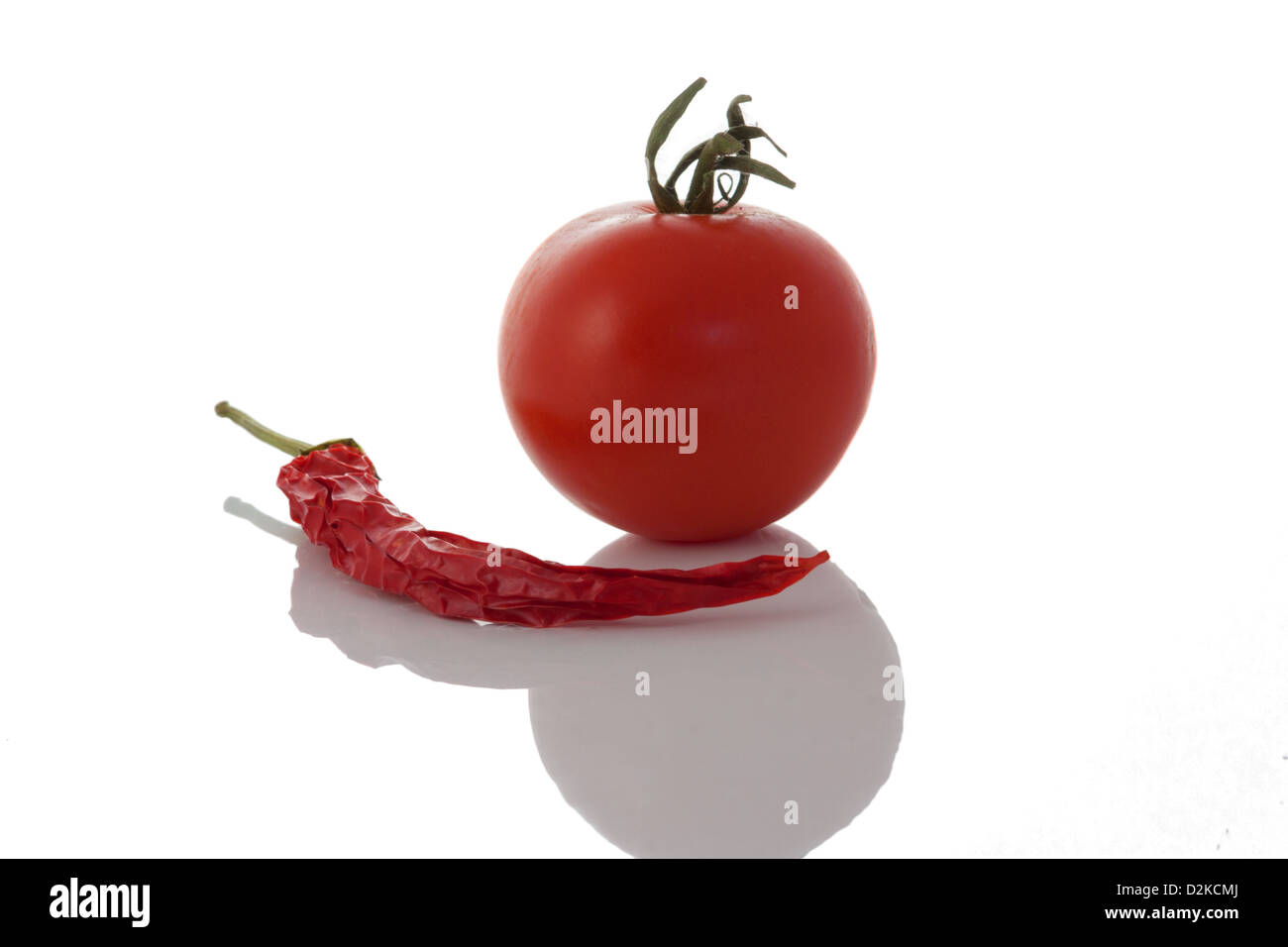 A tomato and a red dried chile Stock Photo - Alamy