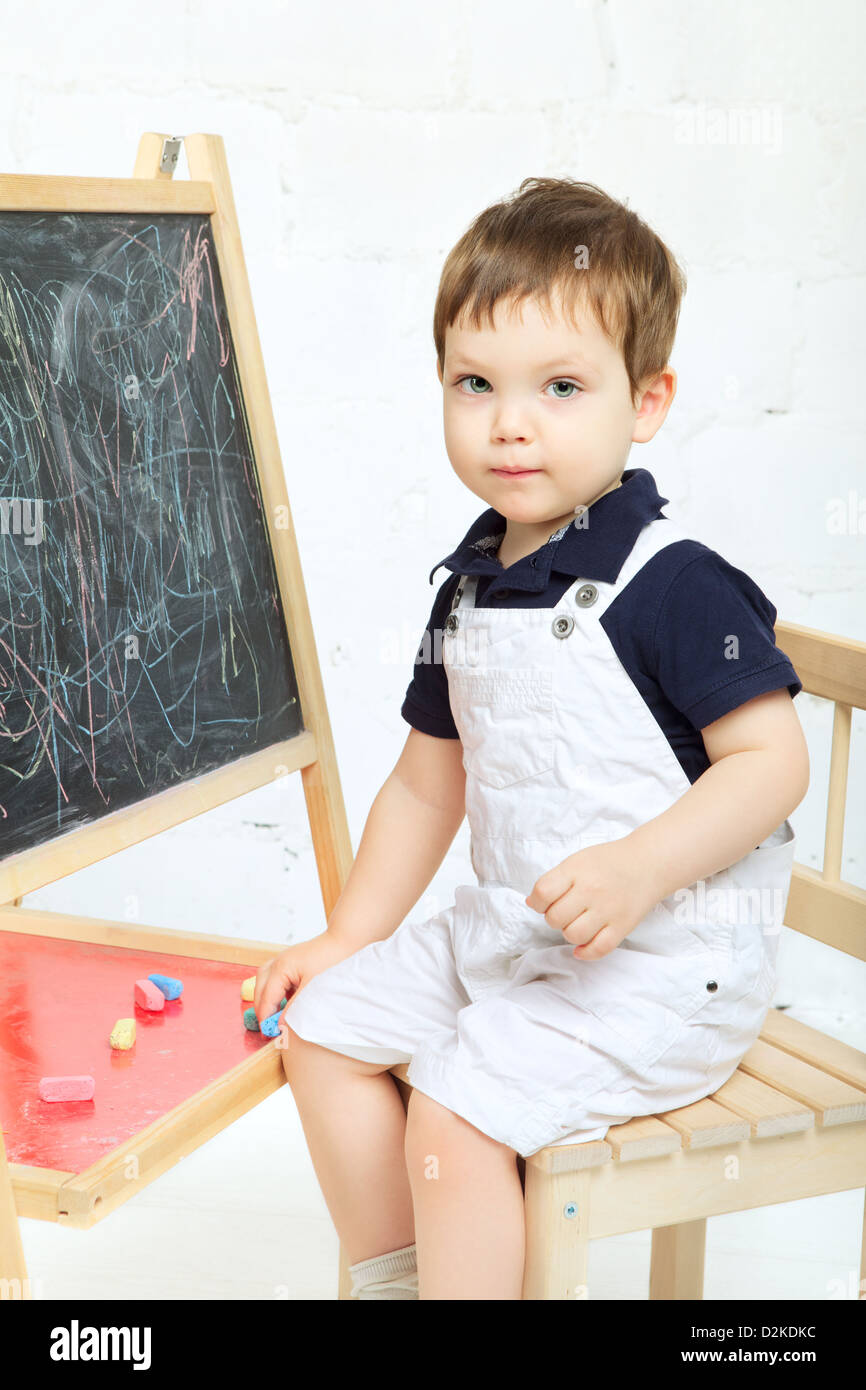 little boy drawing with chalk at blackboard Stock Photo - Alamy