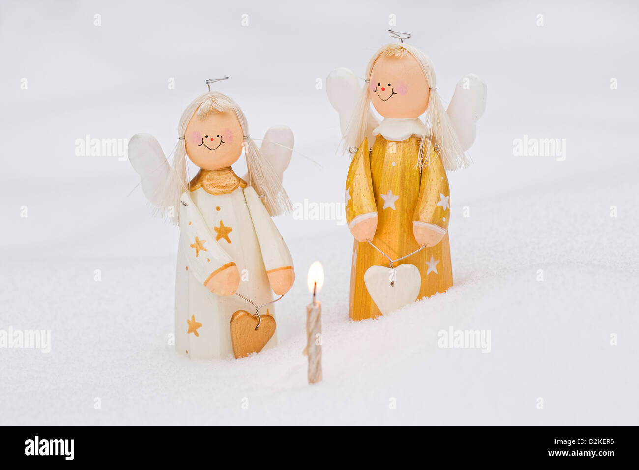 Two decorative wooden angels in the snow Stock Photo - Alamy