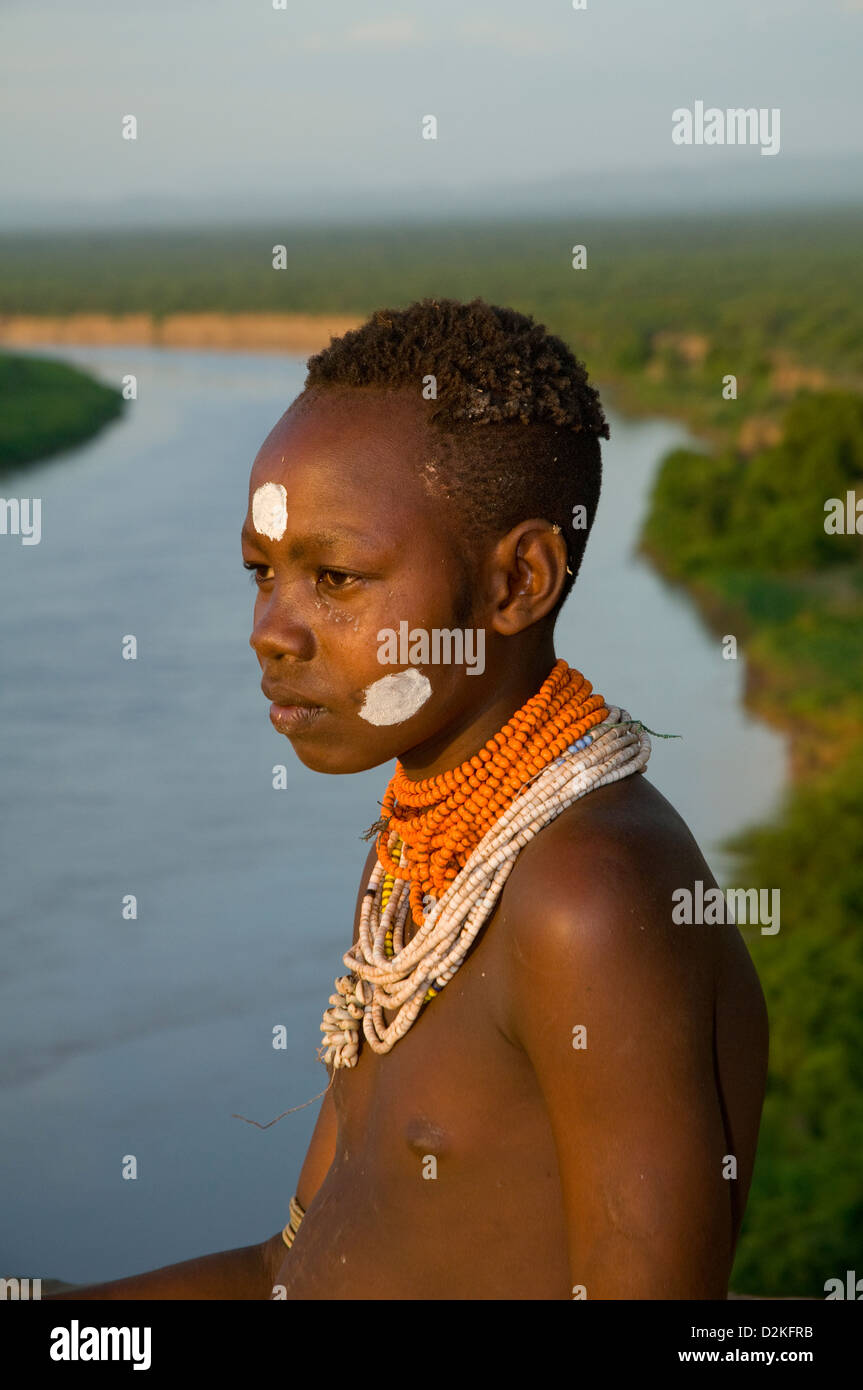 Portrait of decorated Kara woman on bluff with Omo River below-close up ...