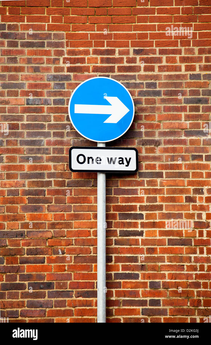 A one way road sign against a brick wall Stock Photo - Alamy