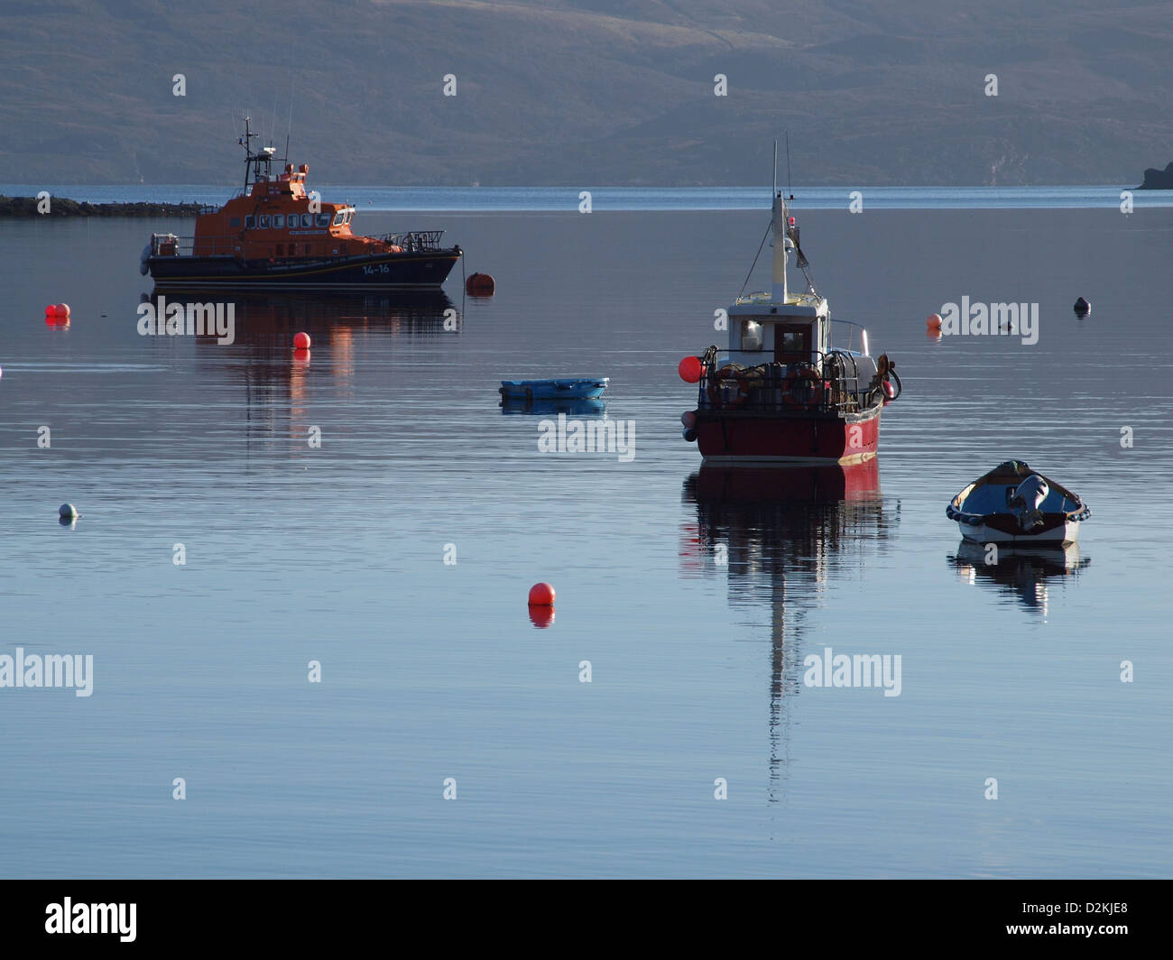 The Portree lifeboat and fishing boats reflected in the still waters of ...