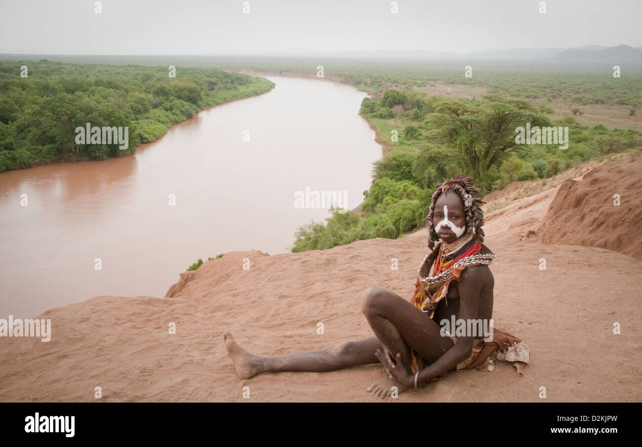 Decorated Kara woman sitting on bluff above Omo River Stock Photo - Alamy