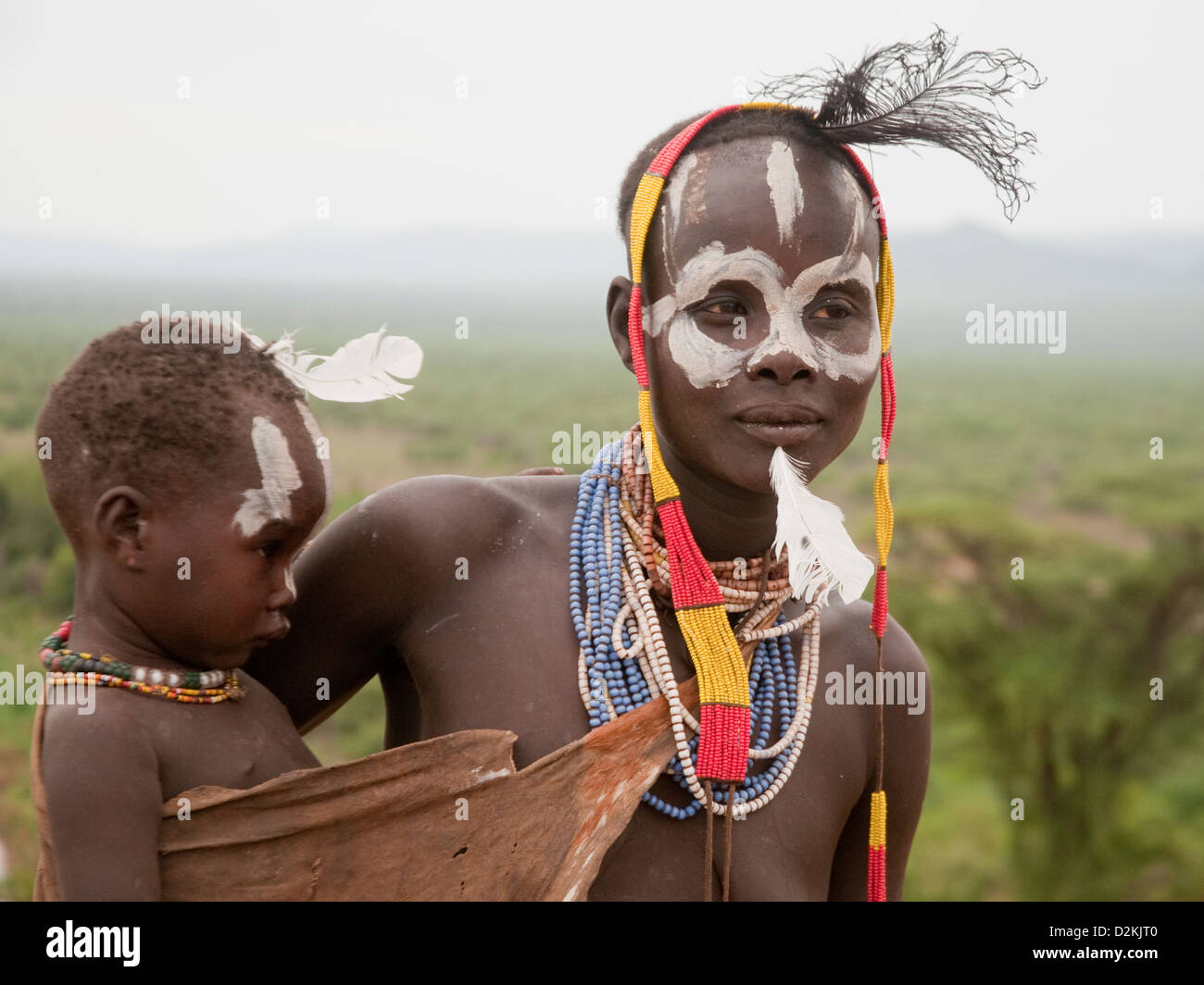 Portrait of ornately decorated Kara woman holding her baby on bluff ...