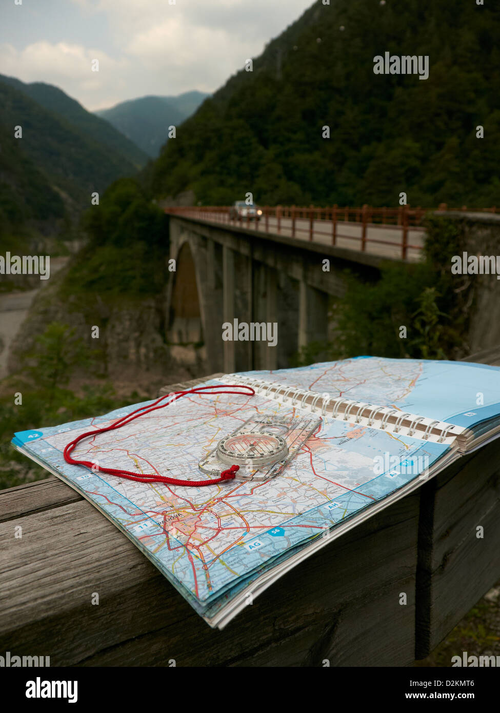 Map and compass with road and bridge in backgroundMap and compass with ...