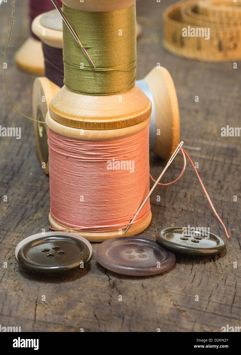Needles and sewing thread on spools with buttons Stock Photo - Alamy