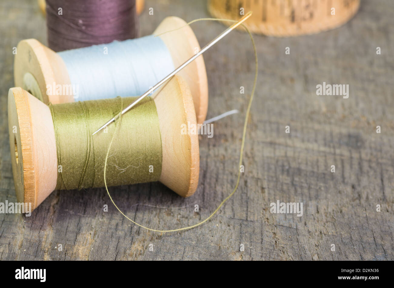 Spools of sewing thread with a needle Stock Photo - Alamy